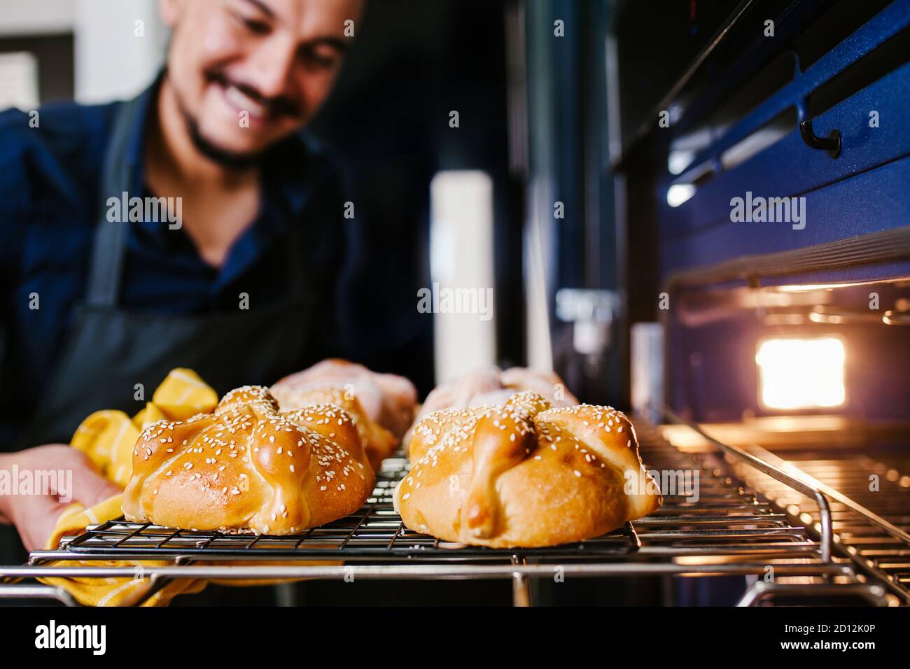 Mexican man baking bread called pan de muerto traditional from Mexico ...