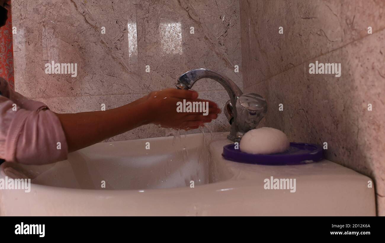 Washing hands in bathroom by masked Children during coronavirus ...