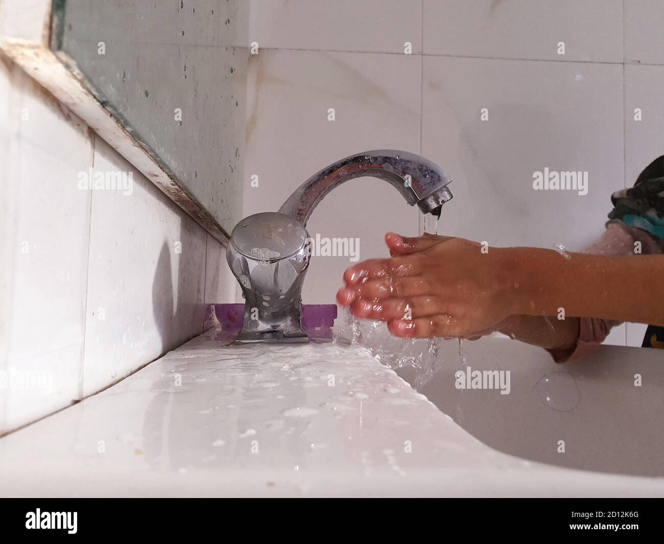 Washing hands in bathroom by masked Children during coronavirus ...