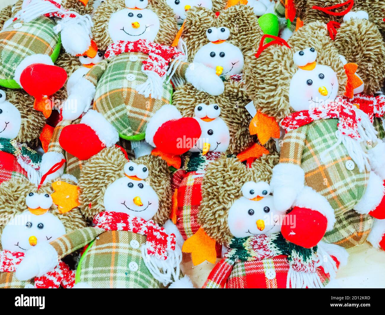 Lots of cute stuffed toy snowmen in plaid clothes. Background texture ...