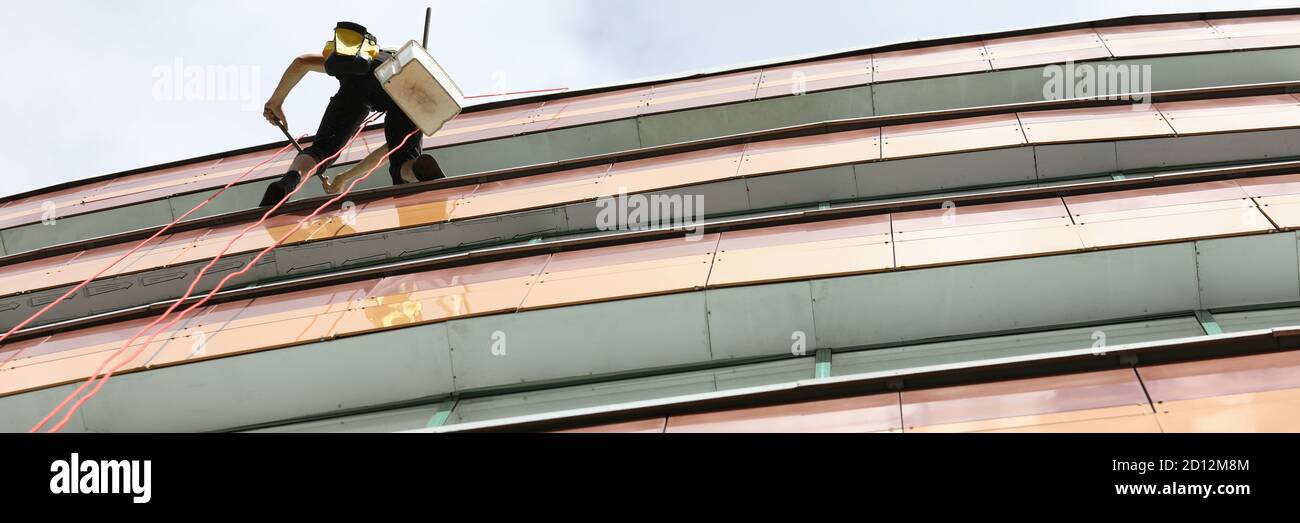 Window cleaner hangs on rope and washes windows Stock Photo - Alamy