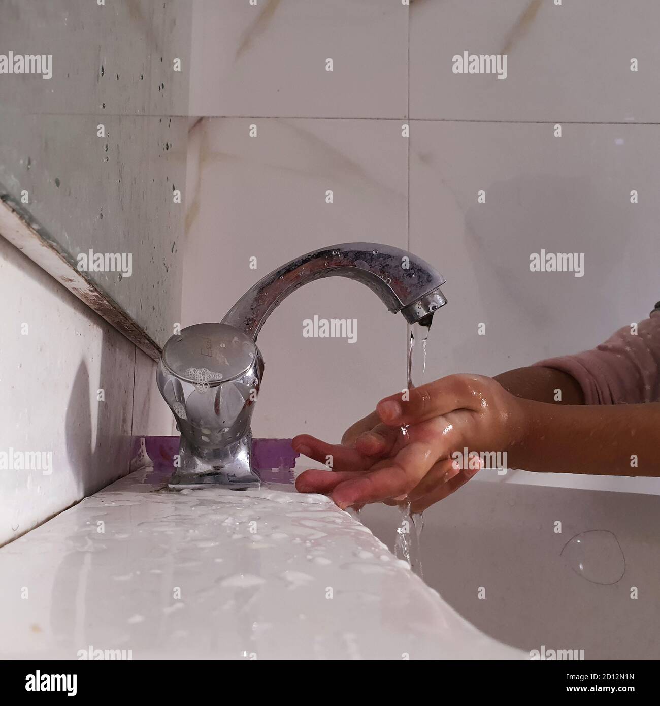 Washing hands in bathroom by masked Children during coronavirus ...