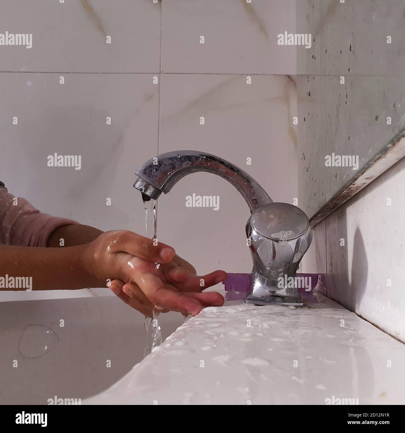 Washing hands in bathroom by masked Children during coronavirus ...