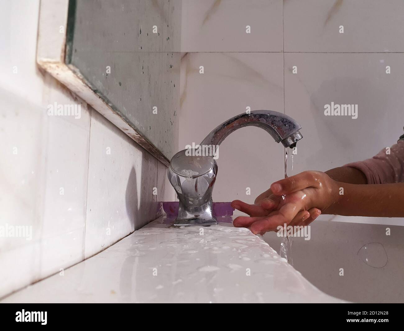 Washing hands in bathroom by masked Children during coronavirus ...