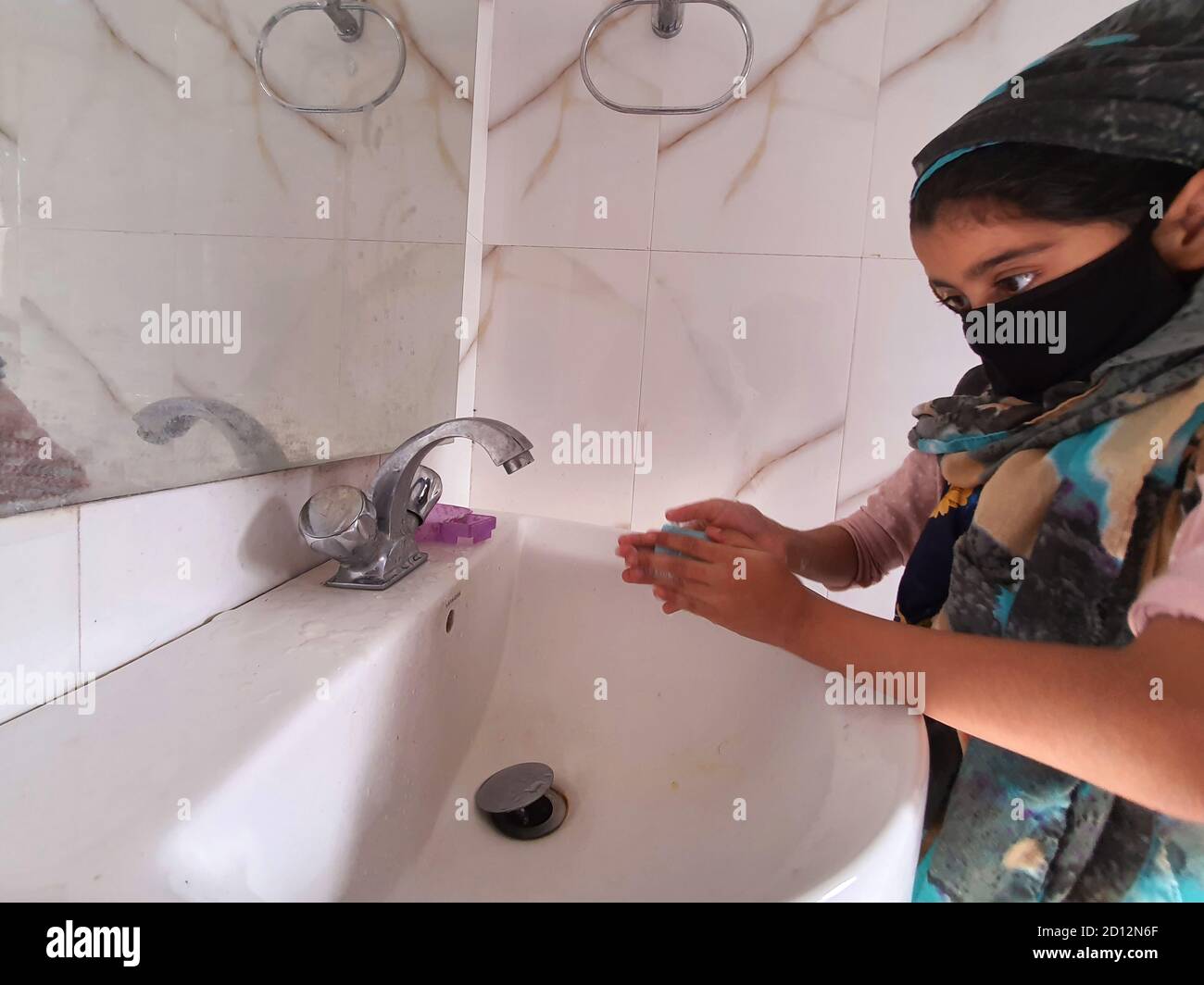 Washing hands in bathroom by masked Children during coronavirus ...