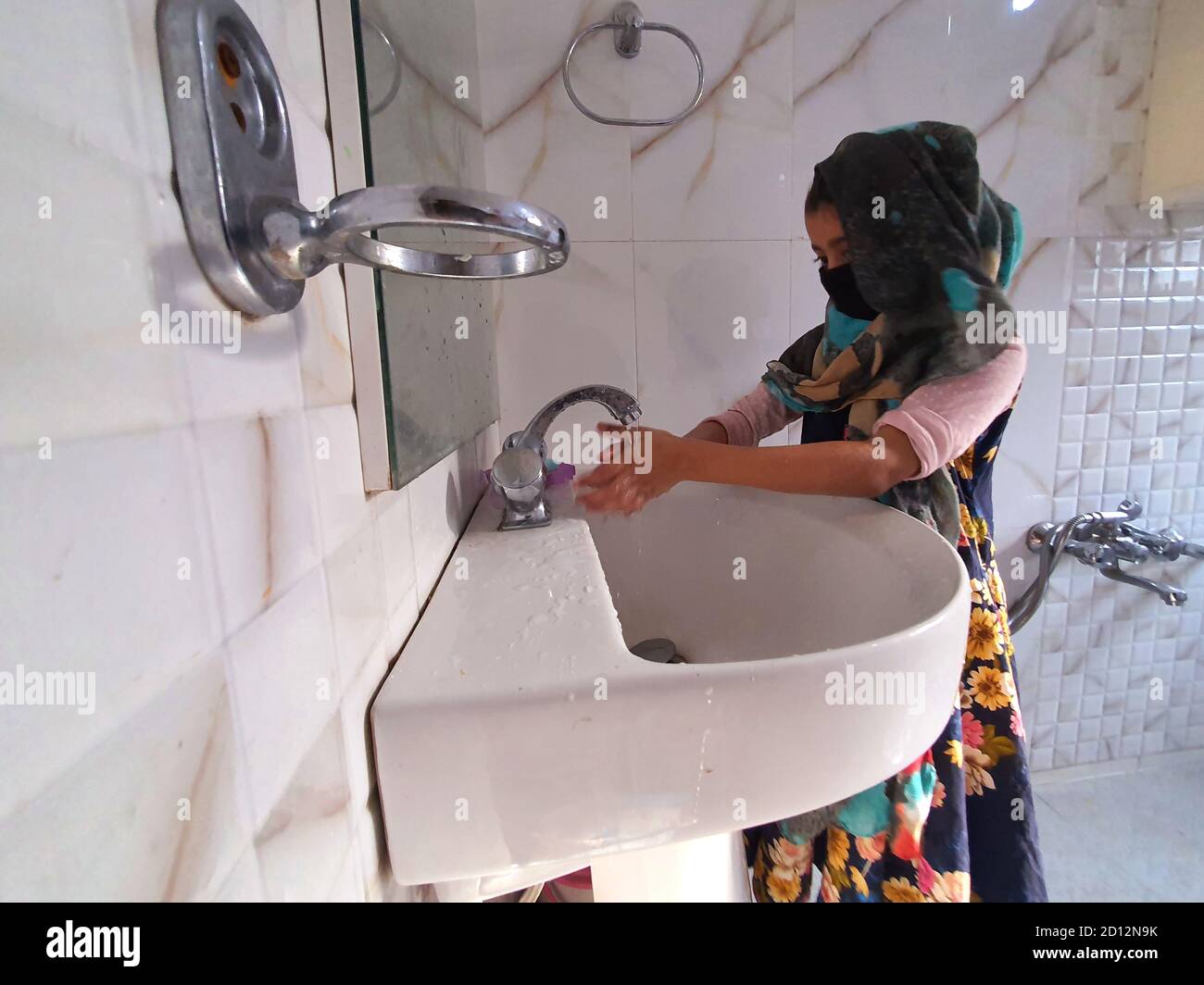Washing hands in bathroom by masked Children during coronavirus ...