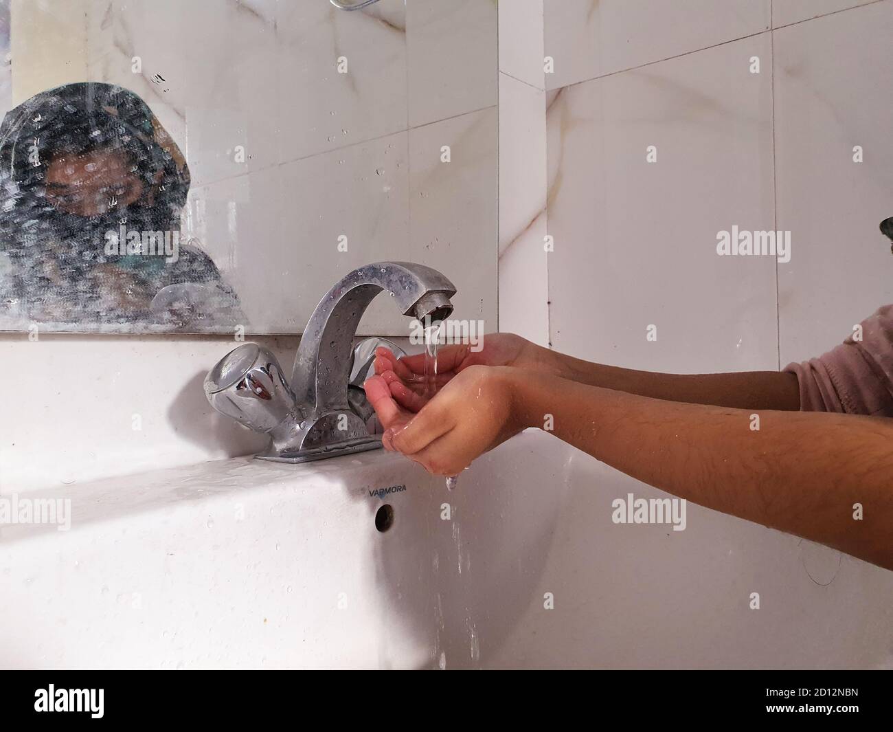 Washing hands in bathroom by masked Children during coronavirus ...