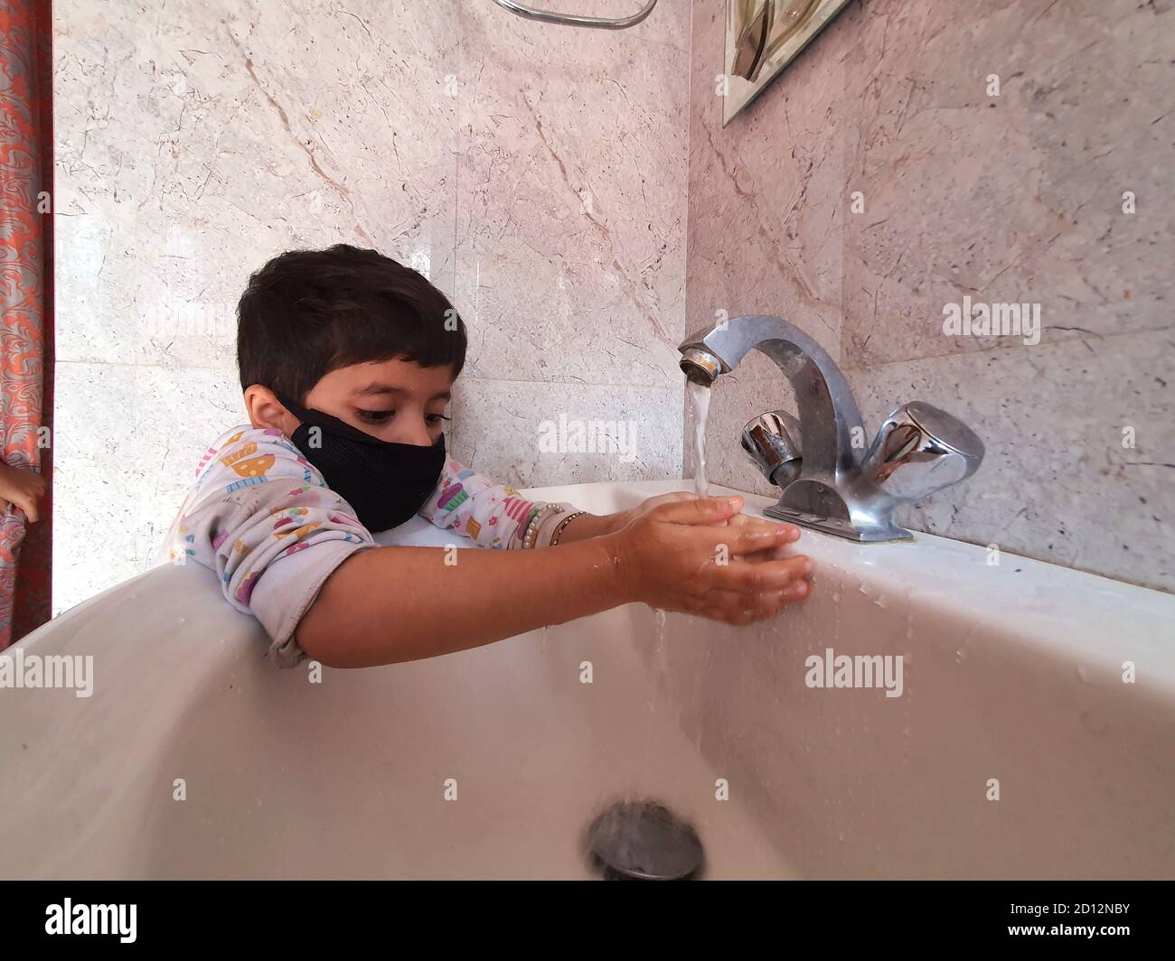 Washing hands in bathroom by masked Children during coronavirus ...