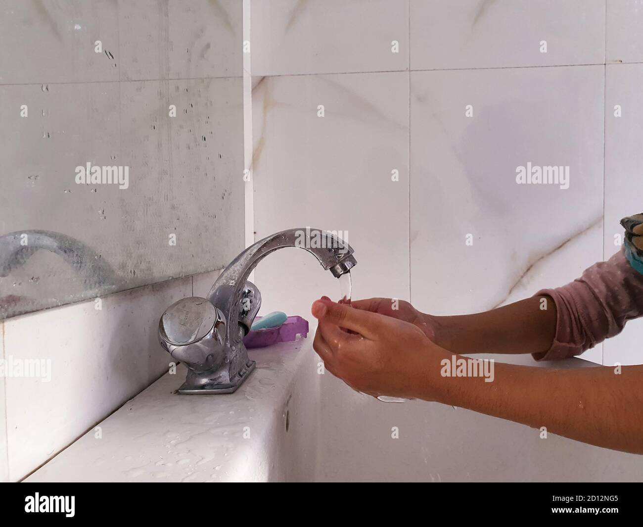 Washing hands in bathroom by masked Children during coronavirus ...