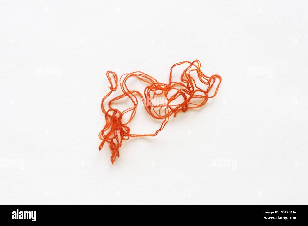 Tangled orange thread on white background isolated Stock Photo - Alamy