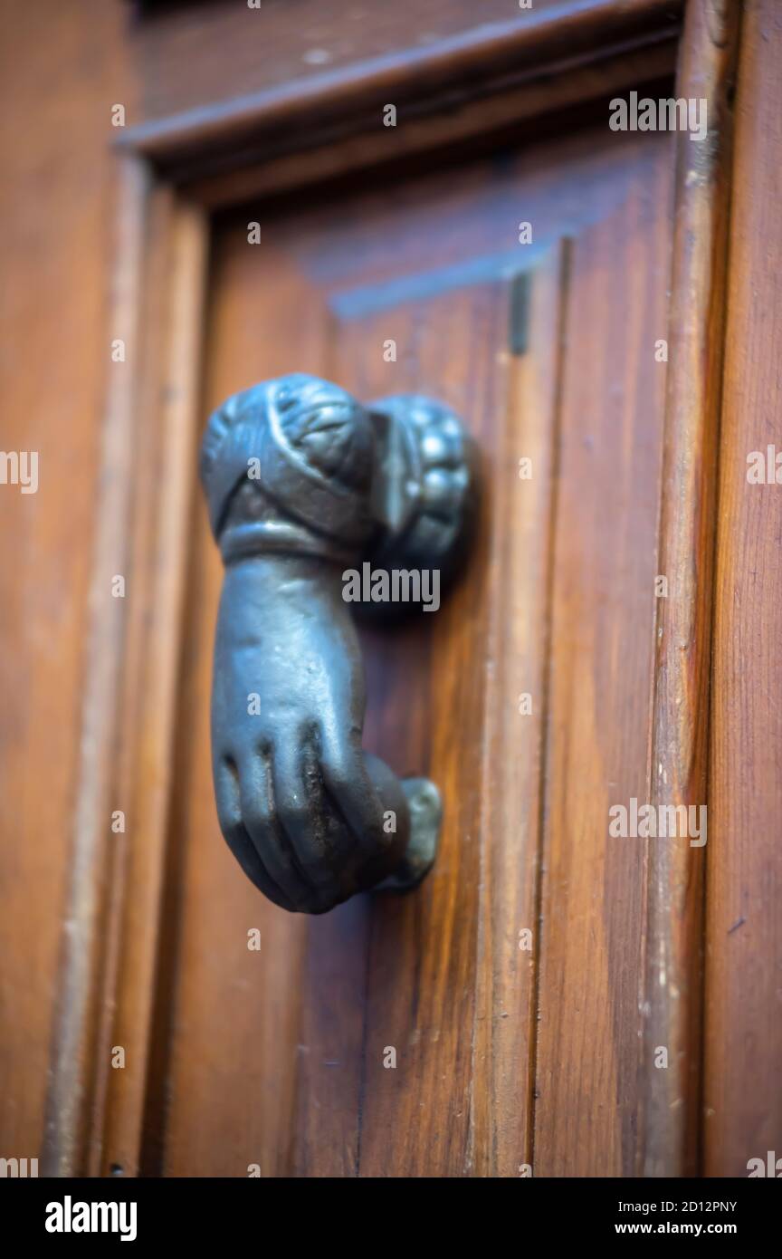 knocker in the shape of a knocking hand in black metal Stock Photo - Alamy