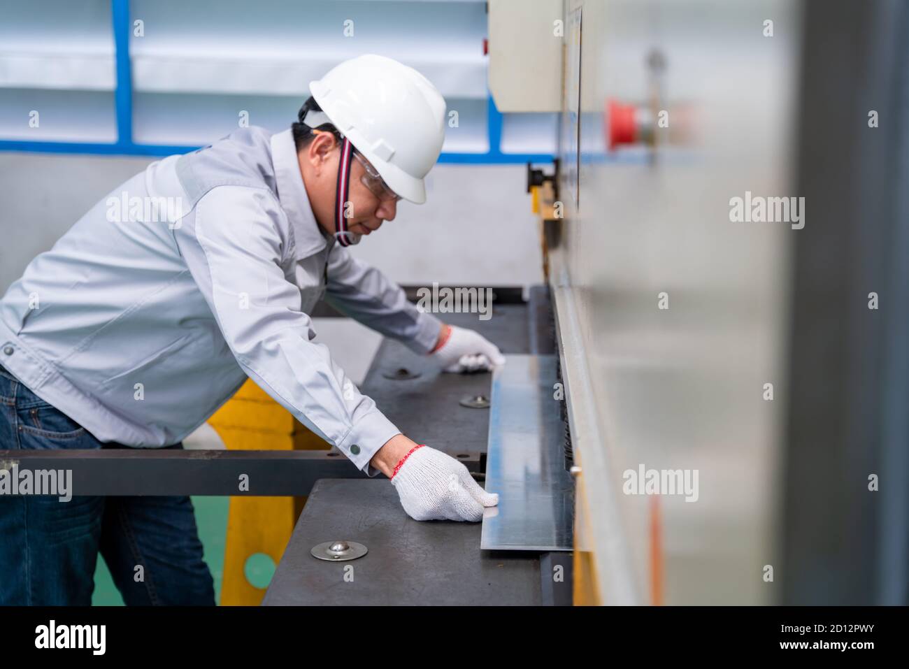 Asian technician worker wearing a safety suit and sheet Metal Shearing ...