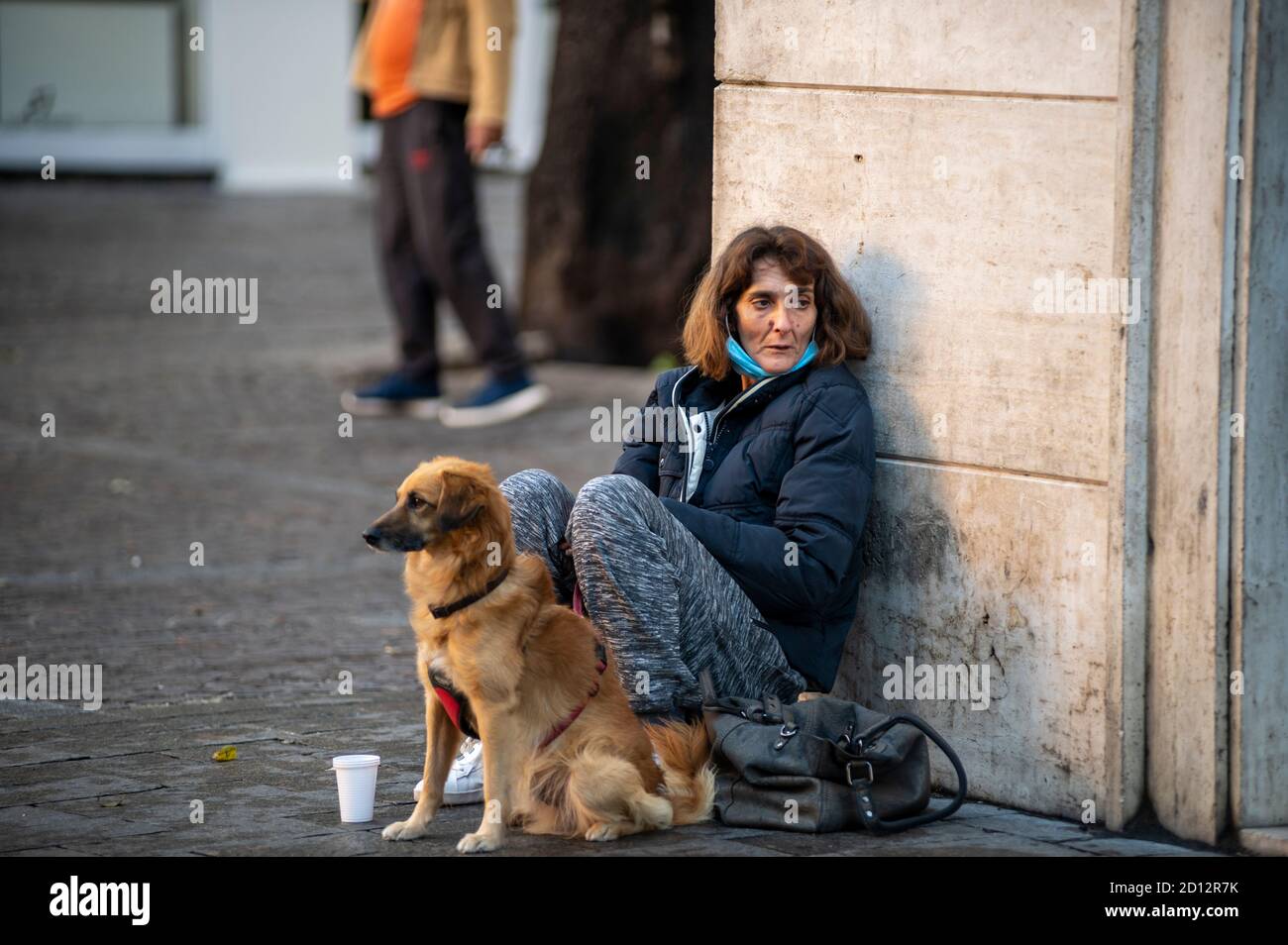 terni,itali october 05 2020:woman with a dog begging for alms Stock ...