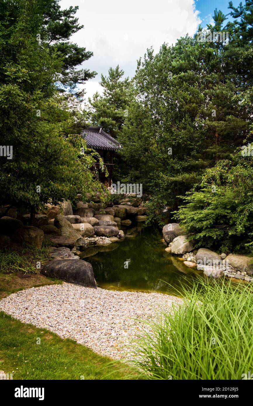 Natural small brook in park with chinese house Stock Photo - Alamy