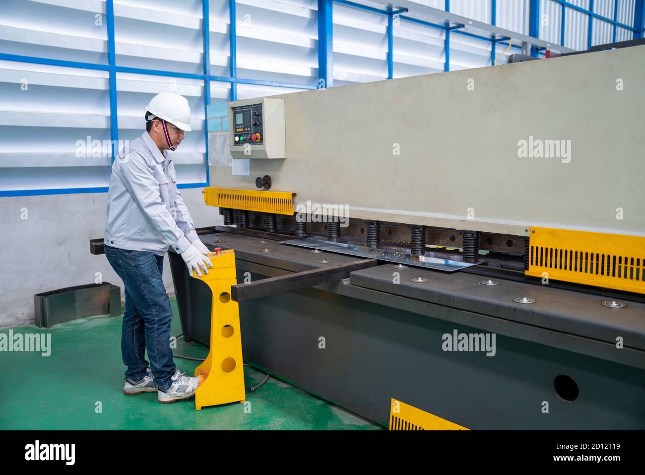 Asian technician worker wearing a safety suit and sheet Metal Shearing ...