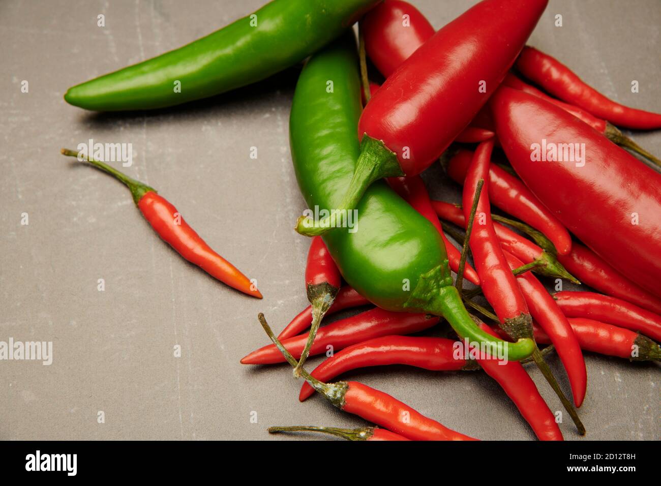 Chili (Capsicum frutescens) peppers on a wooden work top.England, UK ...