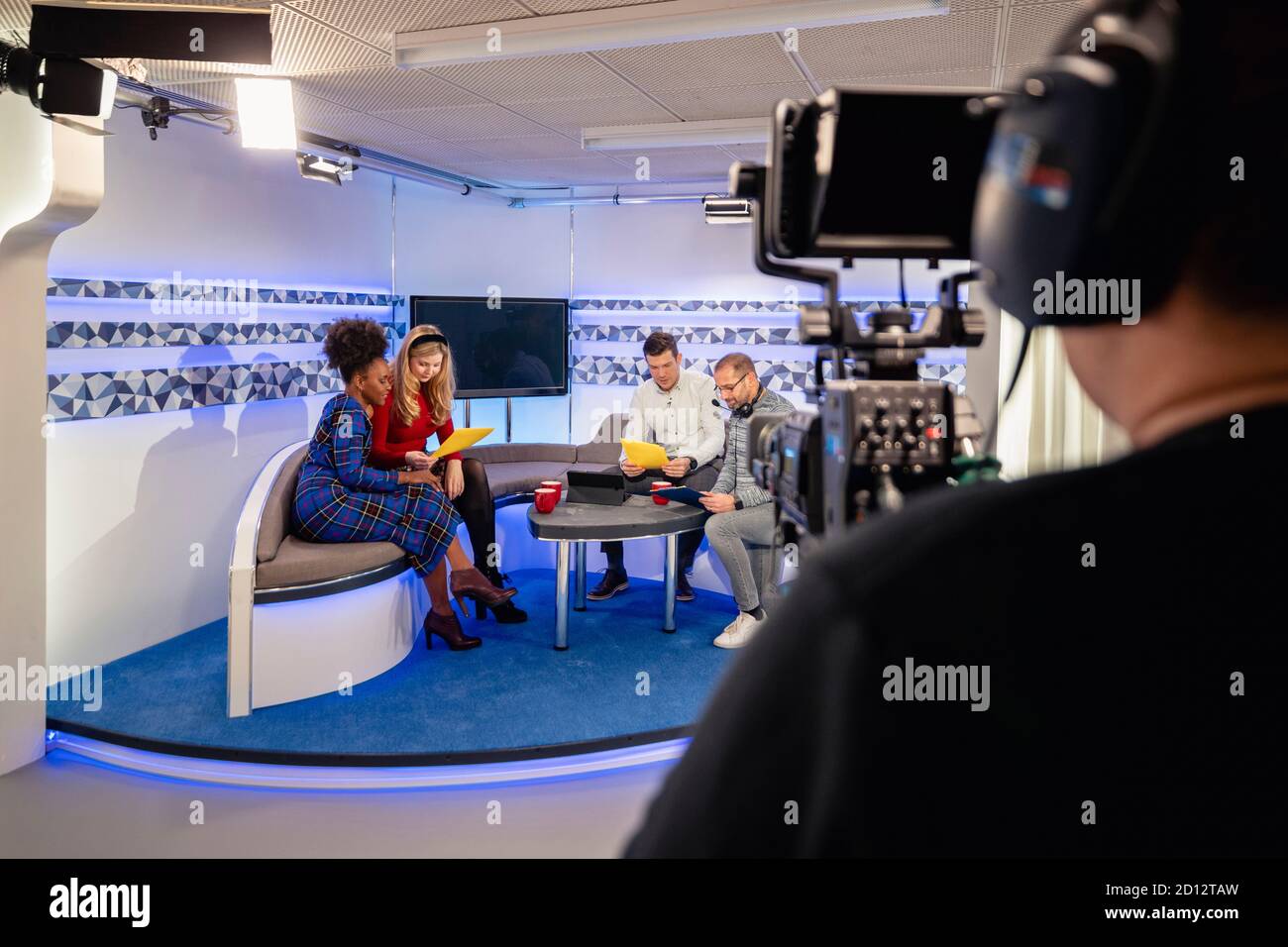 Over the shoulder view of a TV show in the process of being filmed in a ...