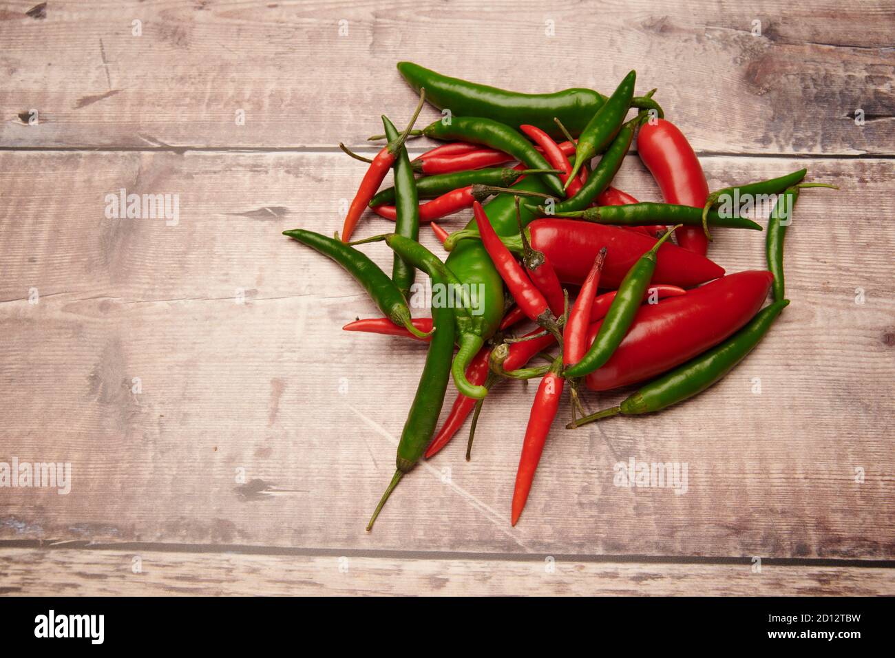 Chilli (Capsicum frutescens) peppers on a wooden worktop.England, UK ...