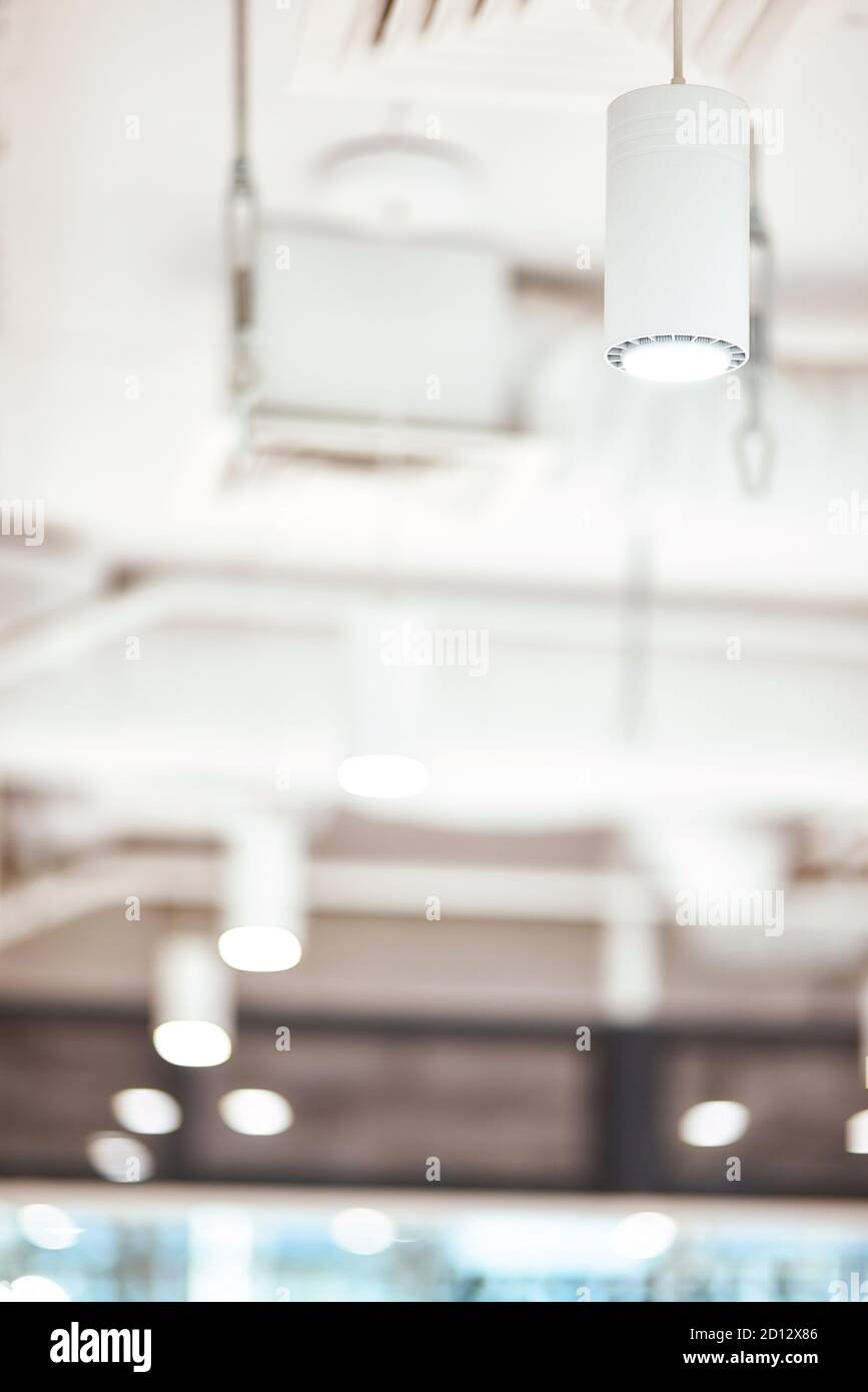 Lighting. Close up of a modern white ceiling lamp shaped tube, interior ...