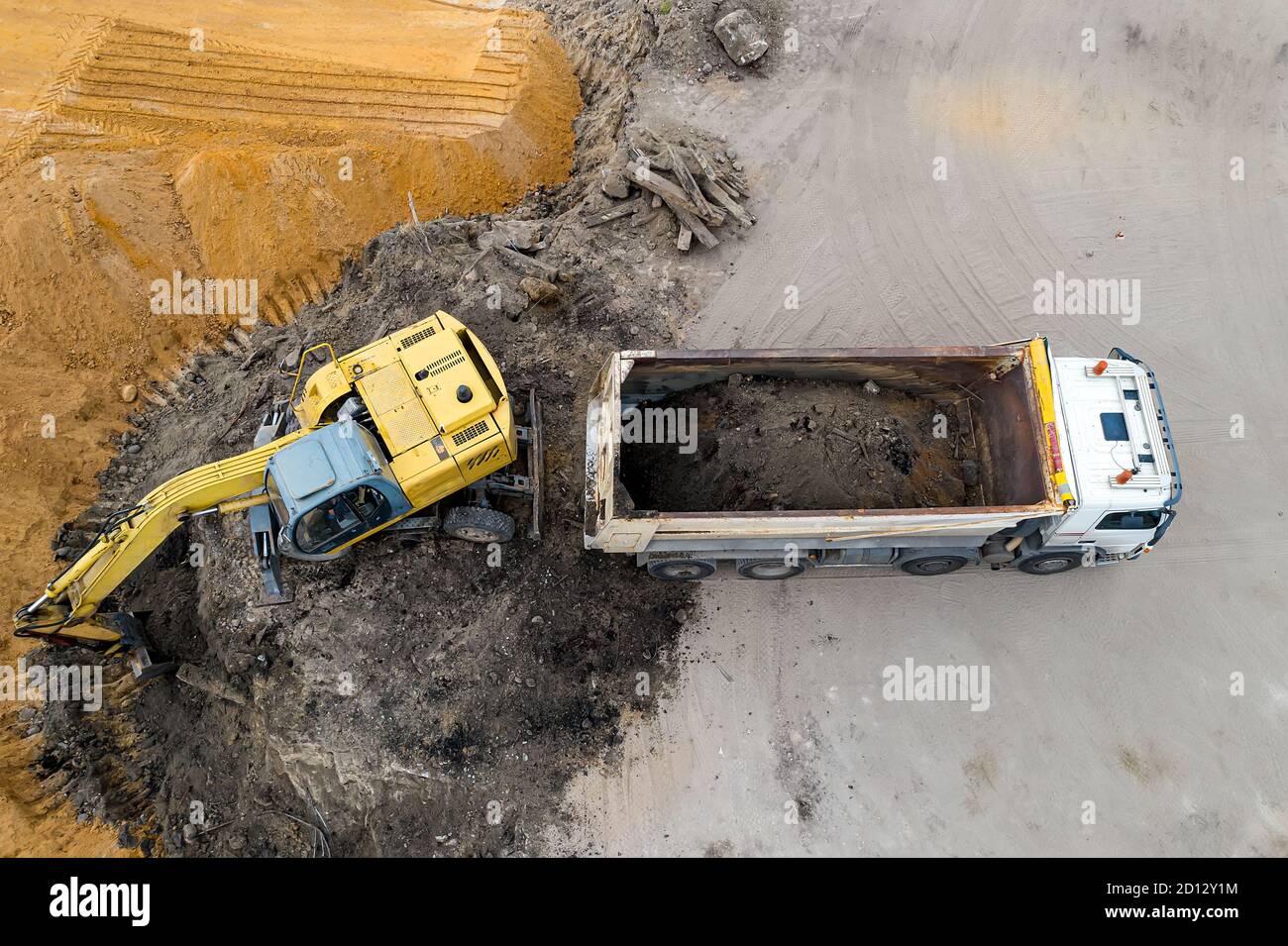 excavator loads sand in a truck top view Stock Photo - Alamy