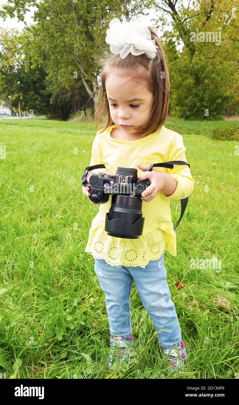 Child with professional camera take photos outside in park background ...