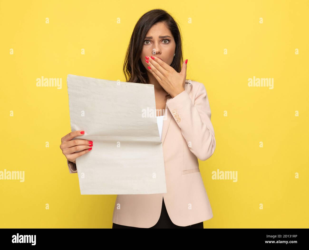 shocked young girl in pink suit reading newspaper, covering mouth in a ...