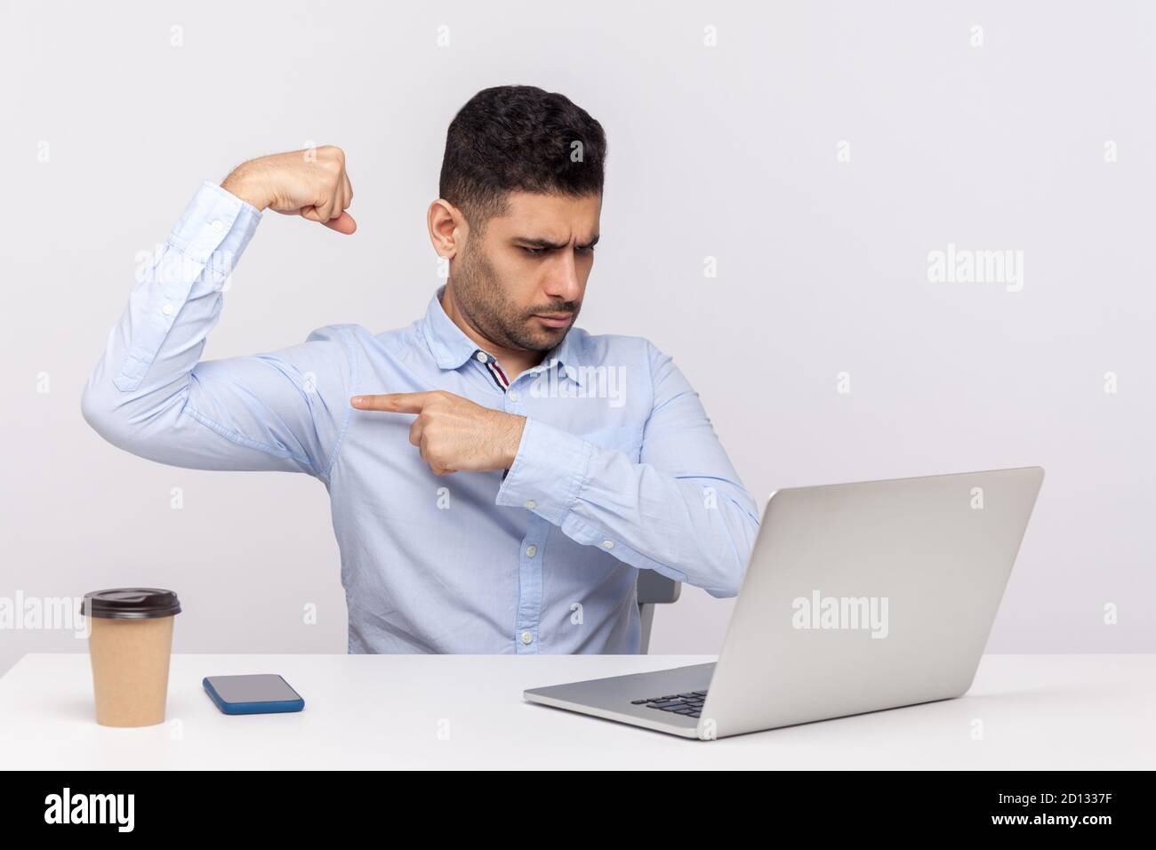 Strong confident man boss sitting office workplace, showing biceps to ...