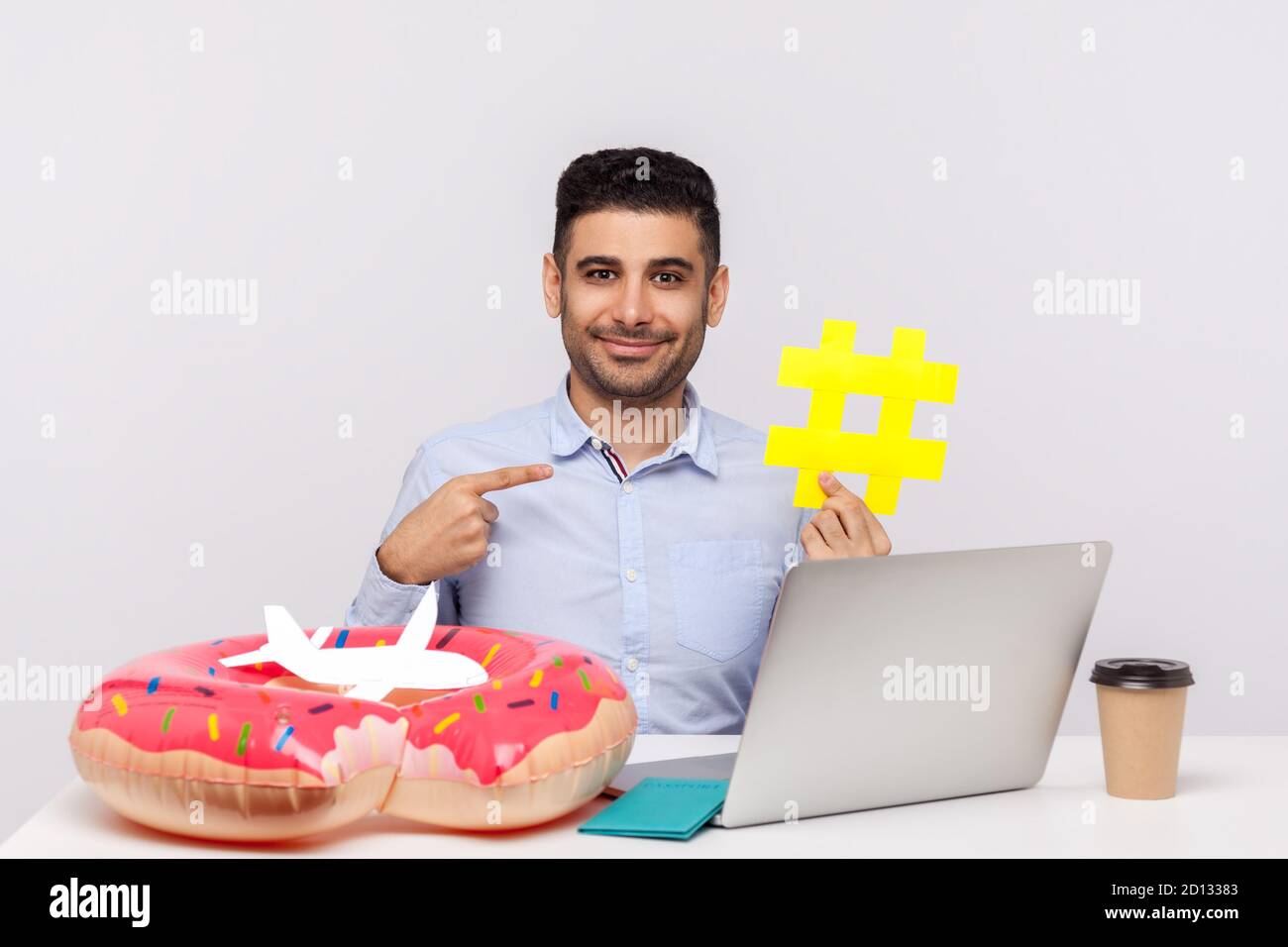 Time to rest! Happy man pointing hashtag symbol, sitting in office ...
