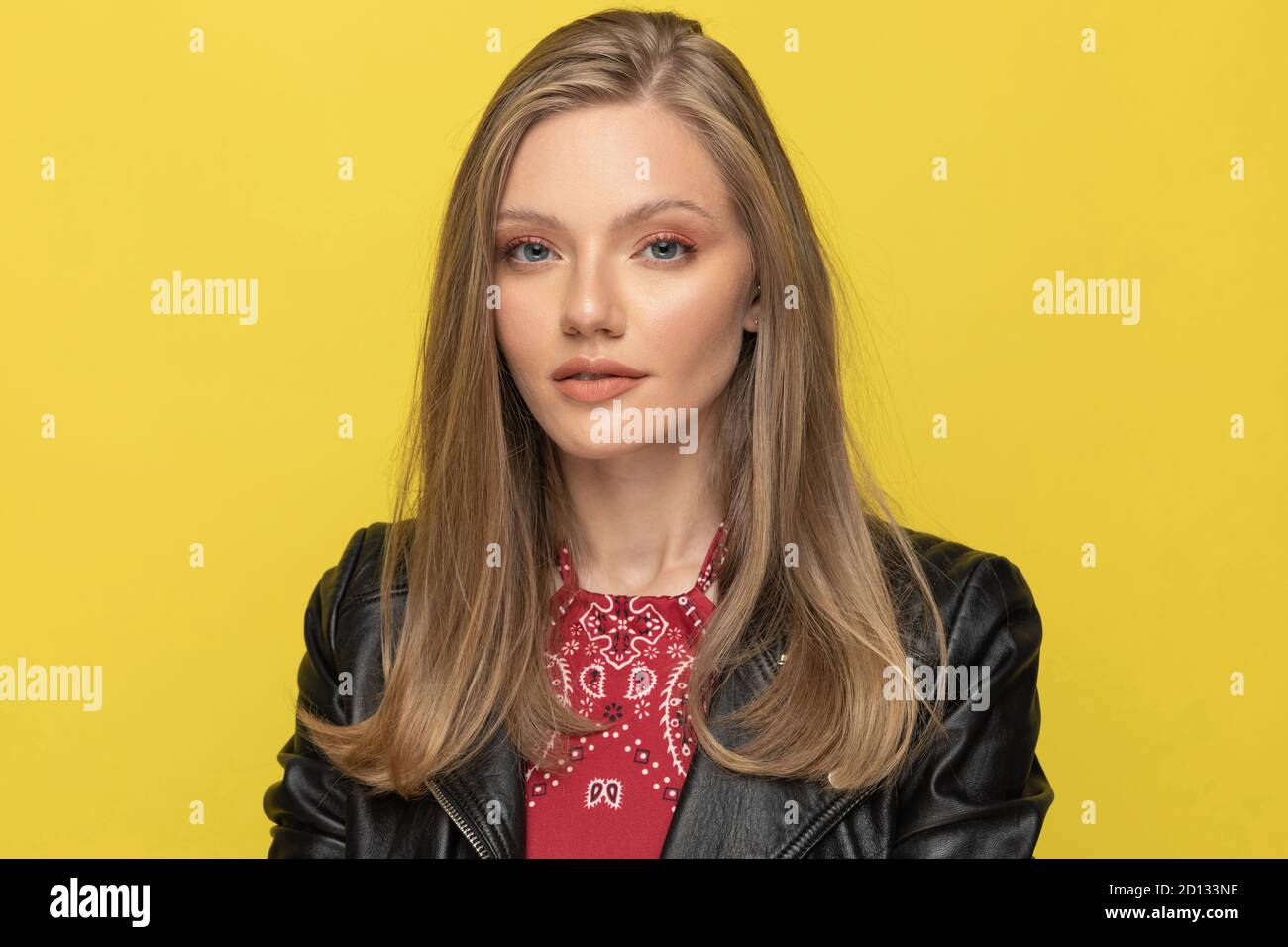 Closeup of serious fashion model looking forward on yellow studio ...