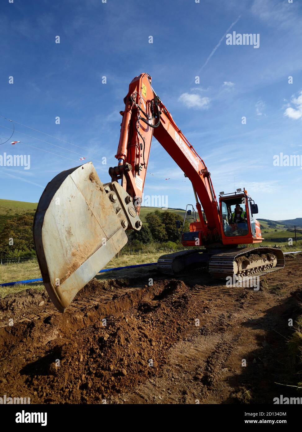 Uk construction industry at work - digger with bucket Stock Photo - Alamy