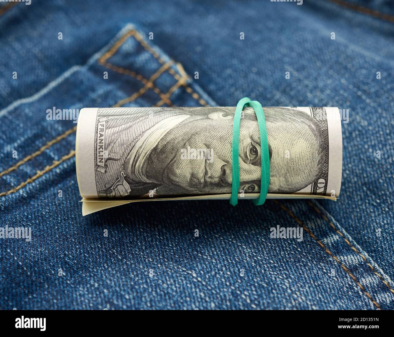 rolled up paper hundred dollar bills and tightened with green rubber ...