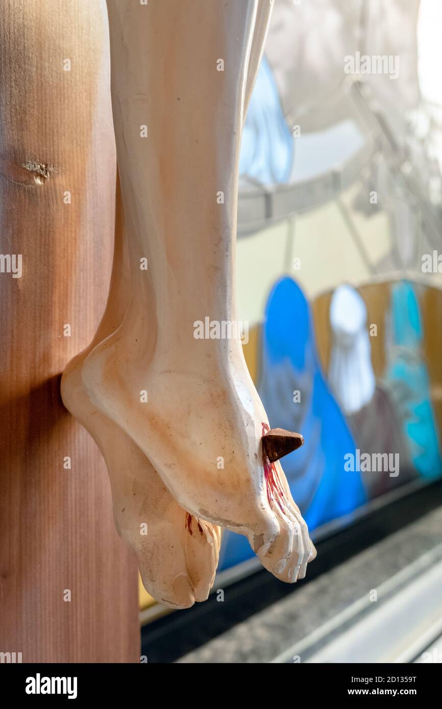 Nailed feet of Jesus Christ on the cross. Detail of sculpture of the ...