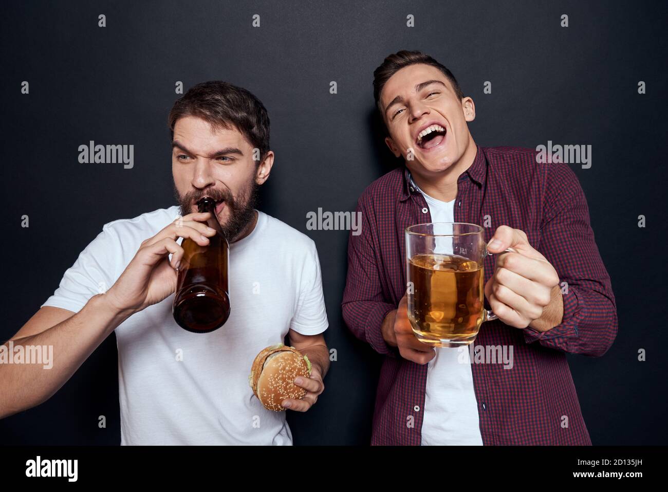 Two drunk friends drinking beer rest fun dark background Stock Photo ...