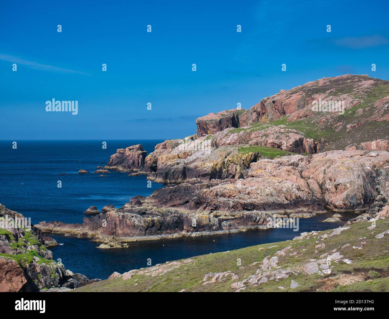 Red granite cliffs on Muckle Roe, Shetland, UK - these rocks are of the ...