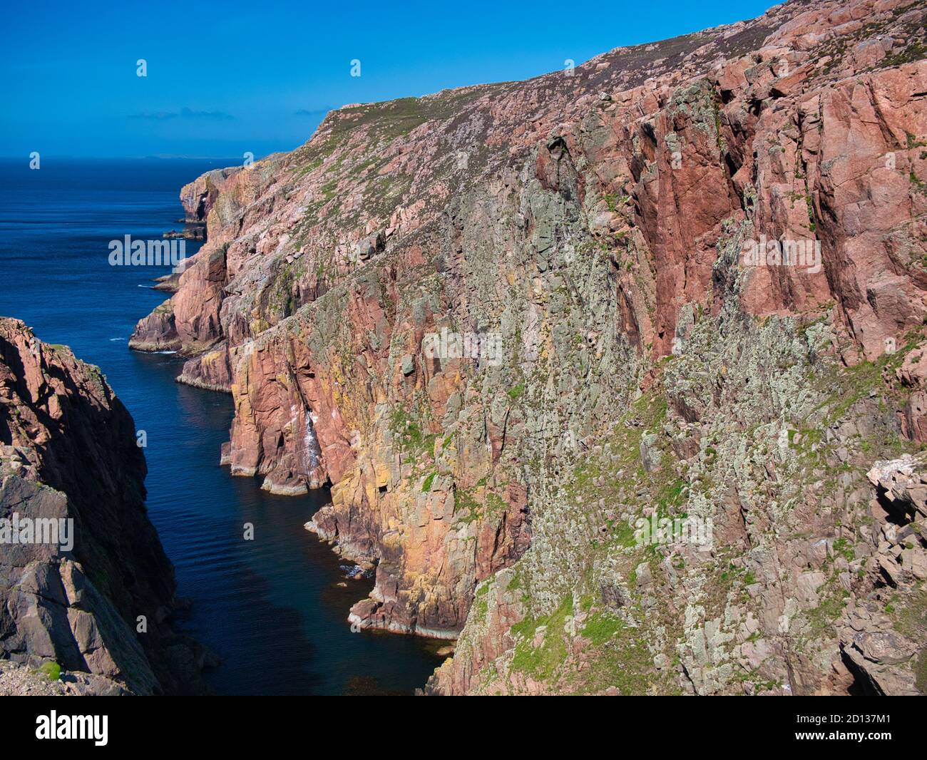 Red granite cliffs on Muckle Roe, Shetland, UK - these rocks are of the ...