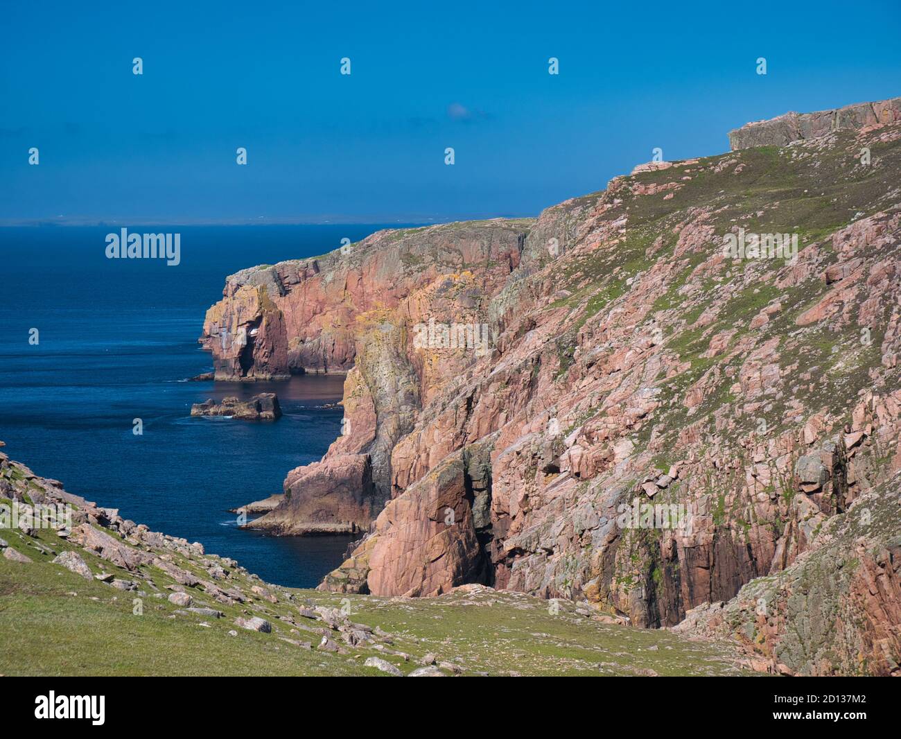 Red granite cliffs on Muckle Roe, Shetland, UK - these rocks are of the ...