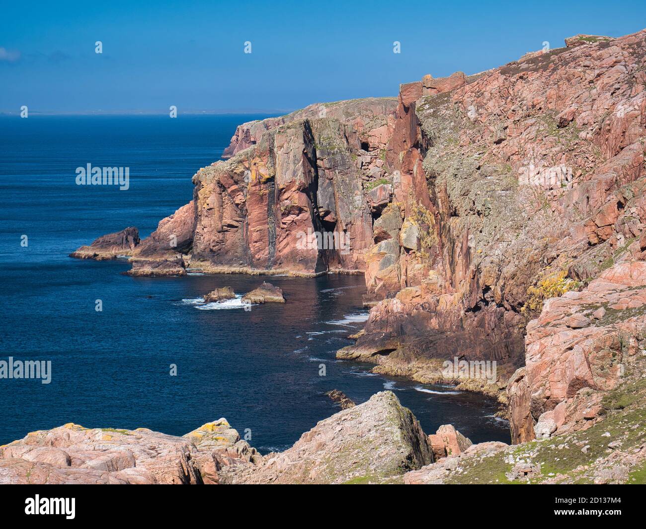 Red granite cliffs on Muckle Roe, Shetland, UK - these rocks are of the ...
