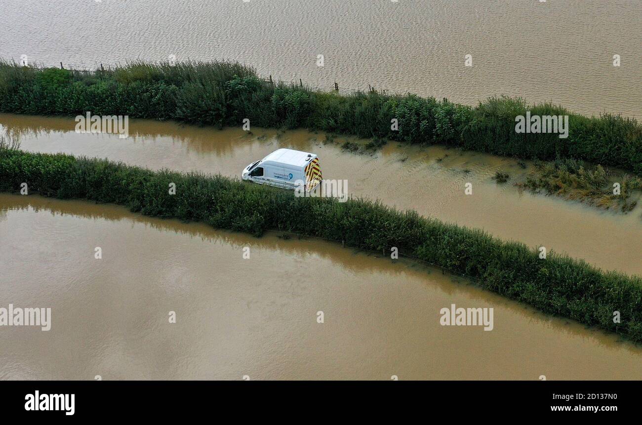 A van is stuck in flood water after the Padbury brook burst its banks ...