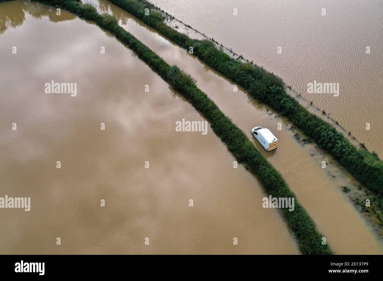 A van is stuck in flood water after the Padbury brook burst its banks ...