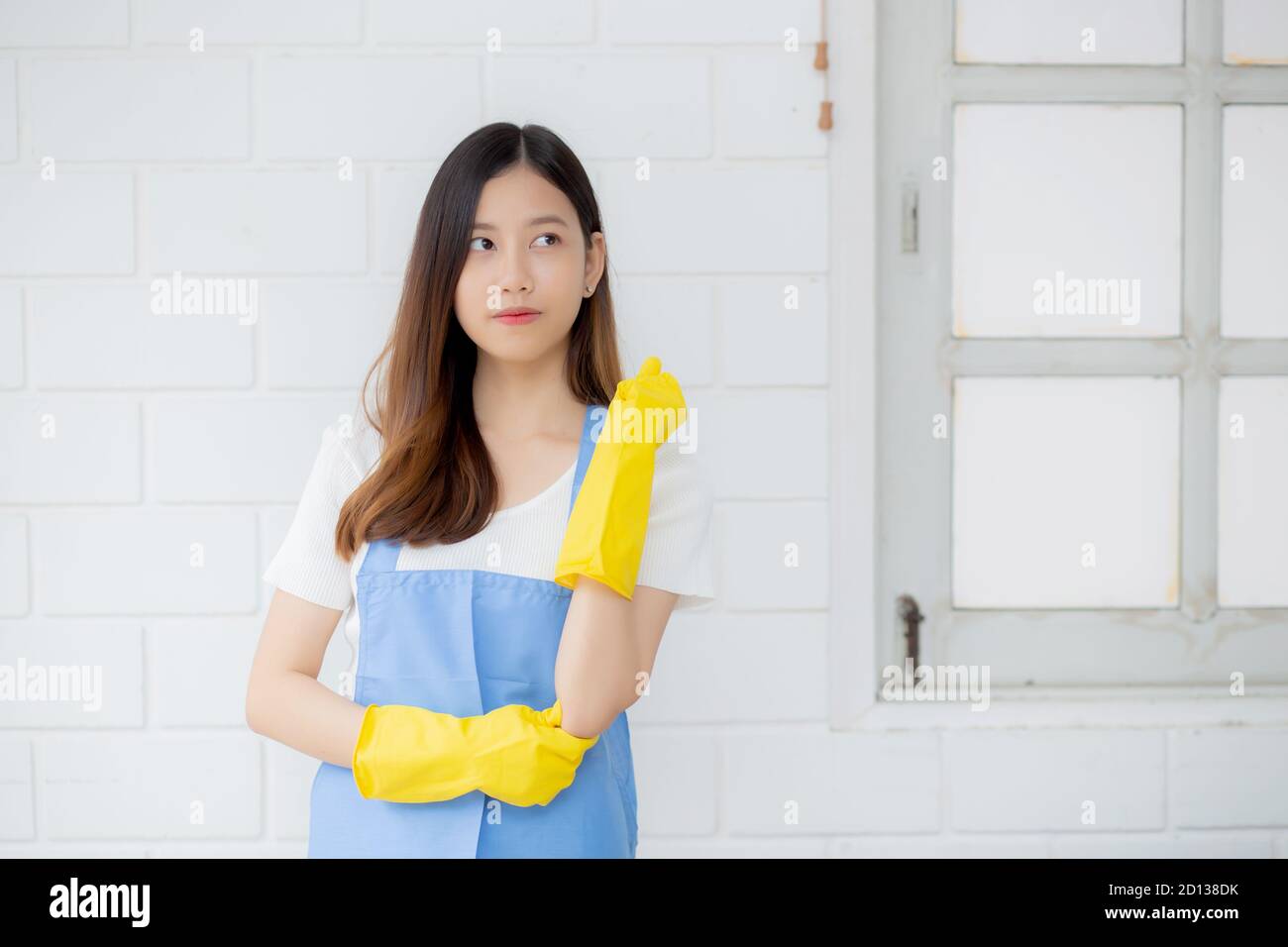 Portrait young asian woman is housekeeper in rubber gloves and apron ...