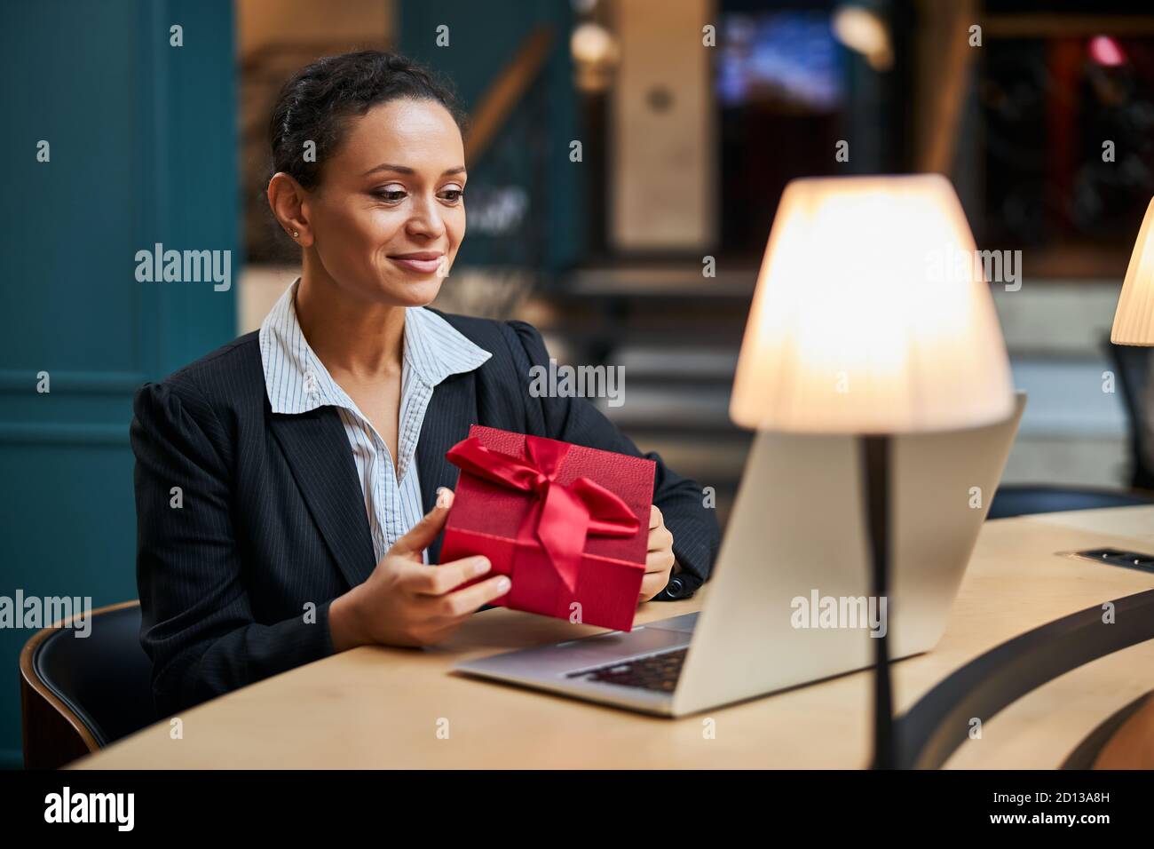 Pleased young female person holding gift box Stock Photo - Alamy