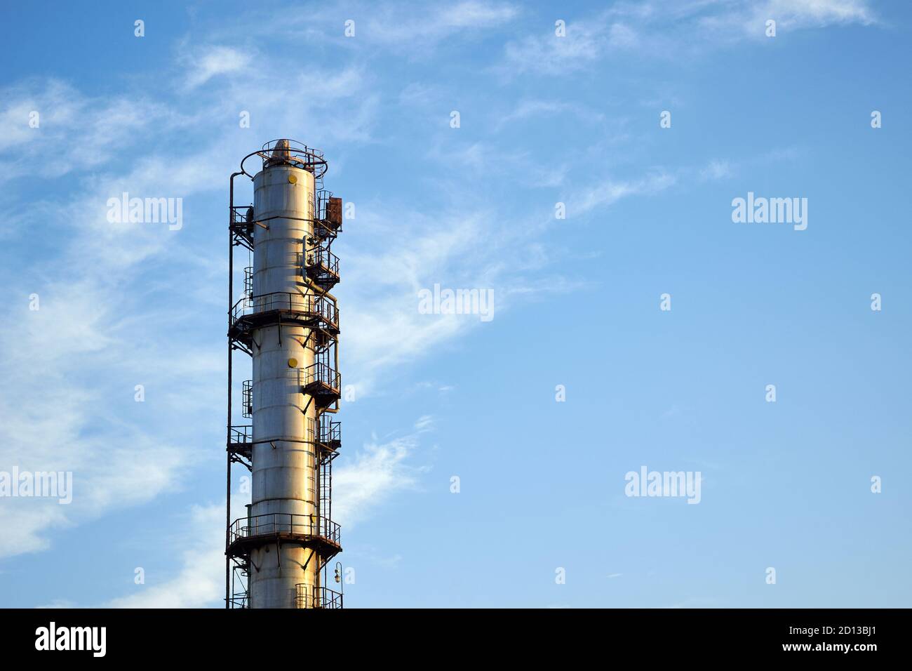 Old distillation column towers with blue sky with clouds background at ...