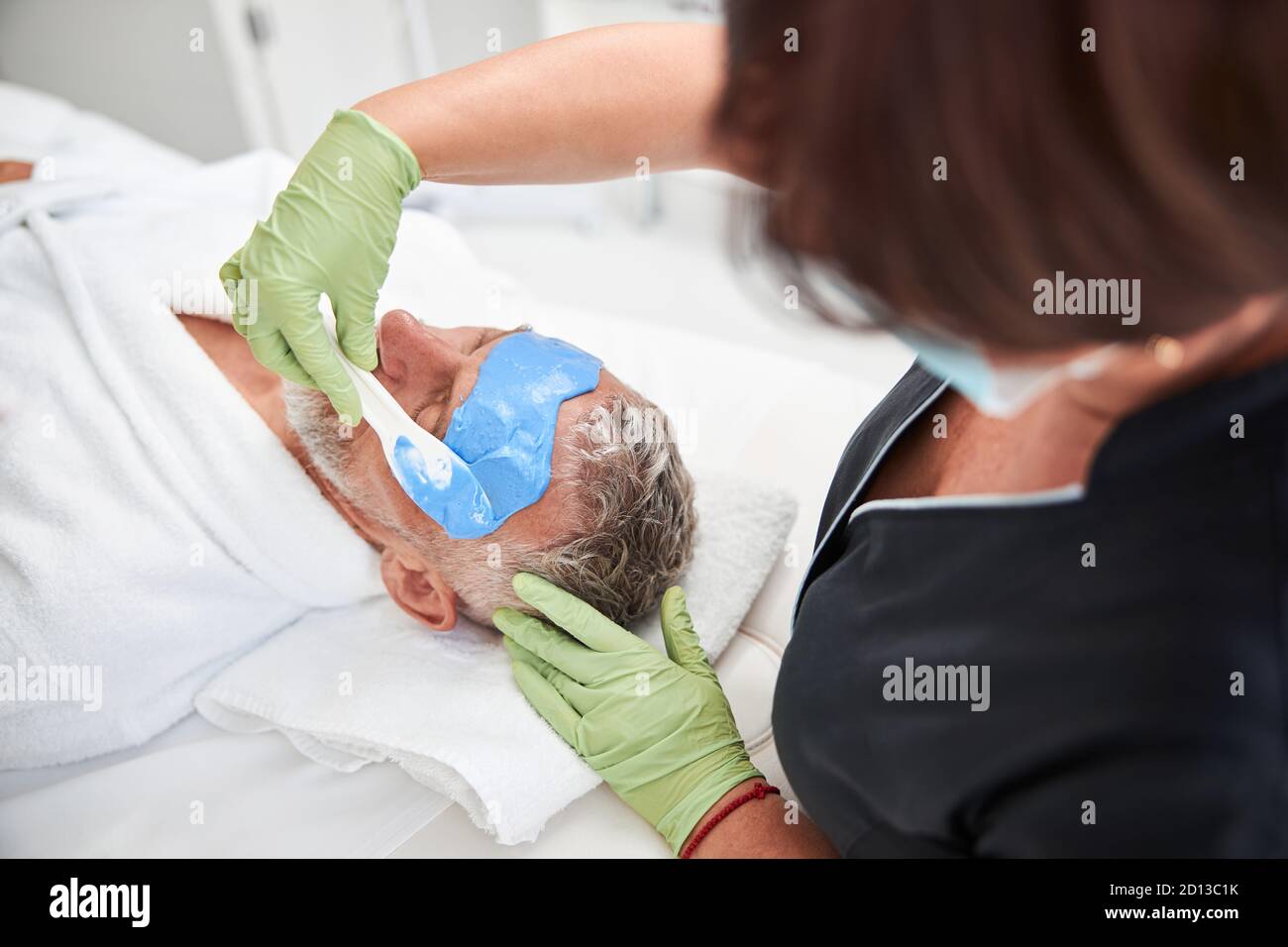 Professional spa therapist doing skincare procedures for a customer ...