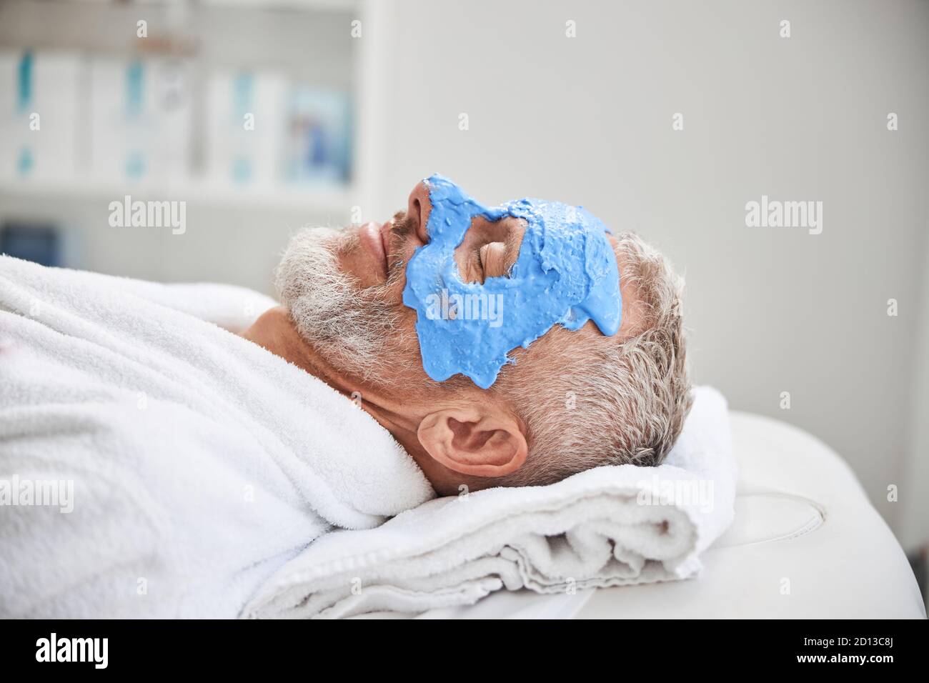 Relaxed elderly man is receiving beautification procedures Stock Photo ...