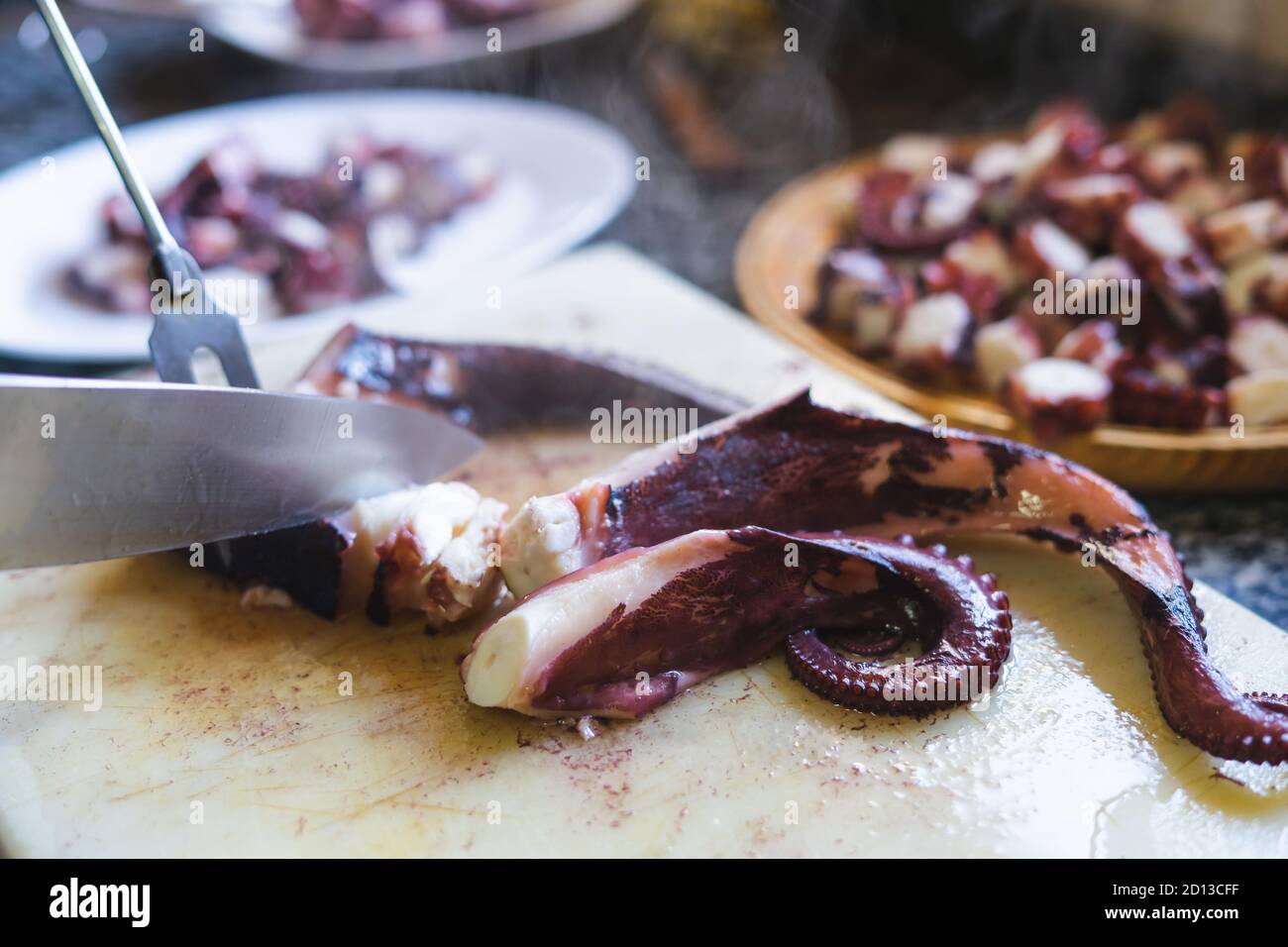 Cutting octopus with knife on kitchen table. Concept of fish Stock ...