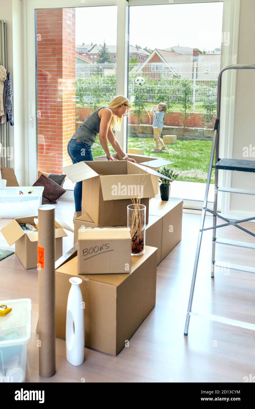 Woman unpacking moving boxes Stock Photo - Alamy