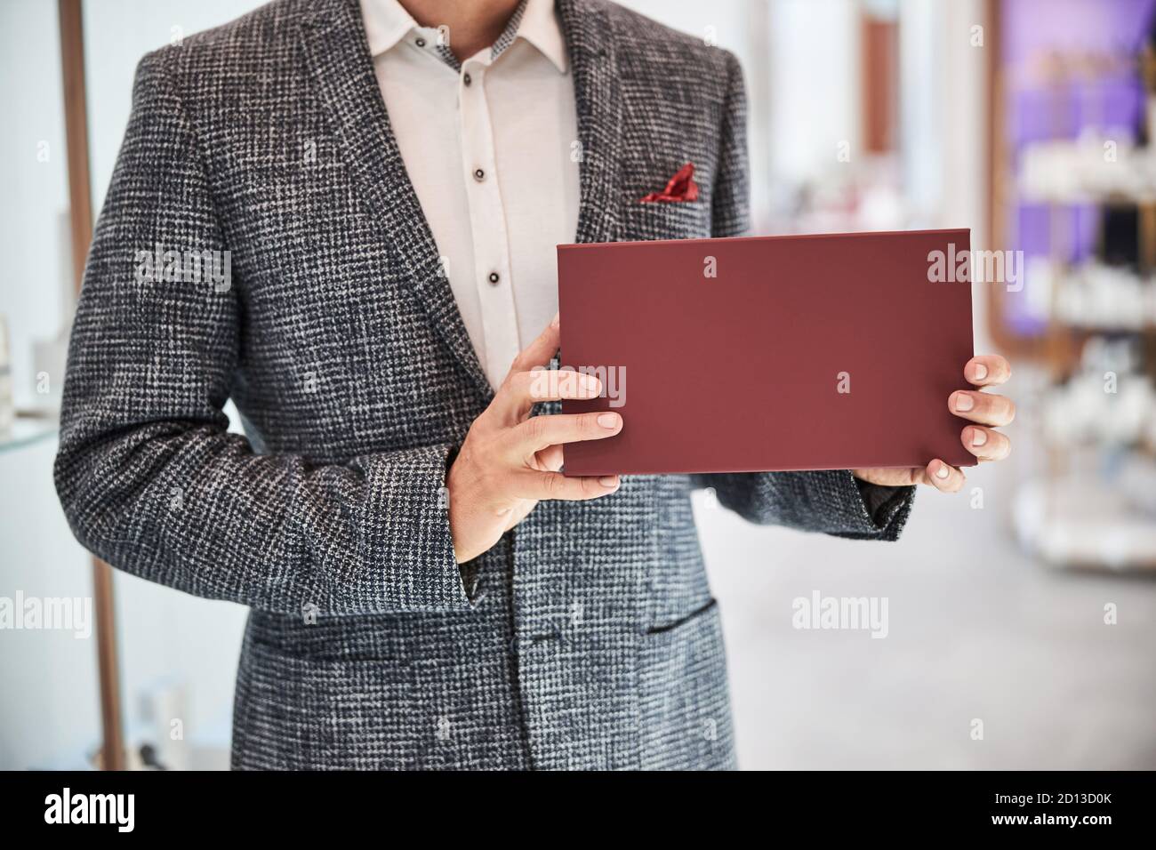 Well-dressed man showing a red rectangular thing to the camera Stock ...