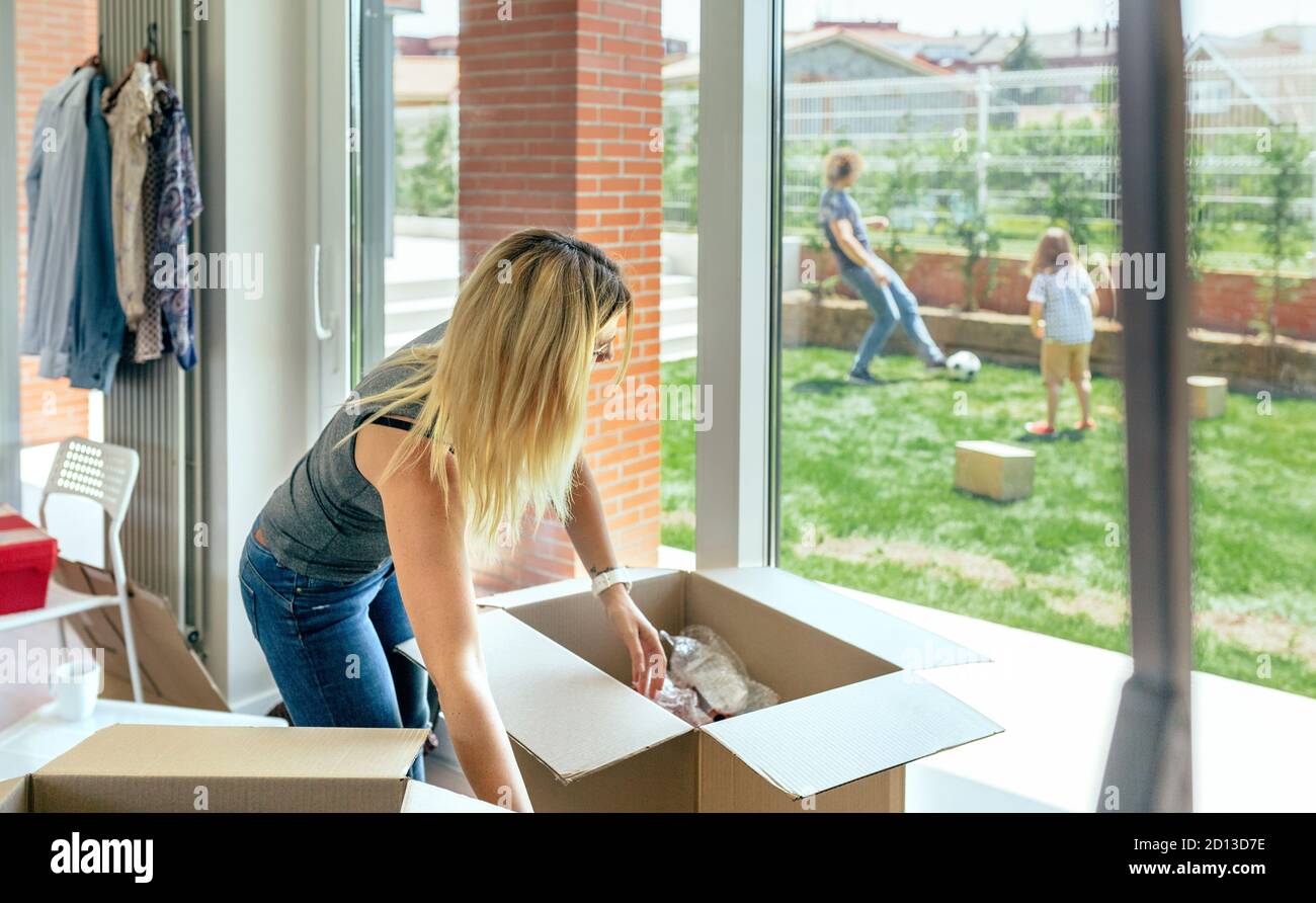 Woman unpacking moving boxes Stock Photo - Alamy