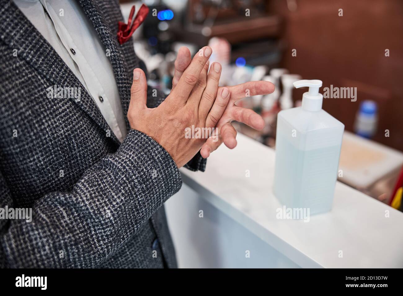 Gentleman sanitizing his hands at the reception Stock Photo - Alamy