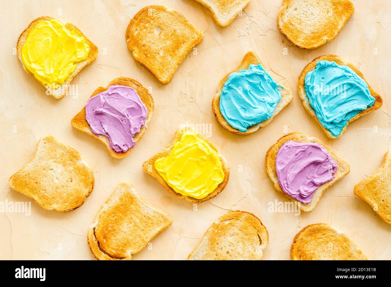Funny toasted bread with colored cheese spread. Overhead view Stock ...